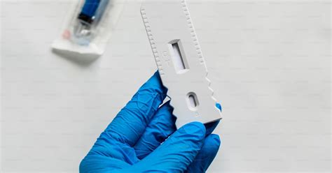 파란 장갑을 낀 사람이 하얀 물체를 들고 있다 사진 Unsplash의 코로나 테스트 이미지