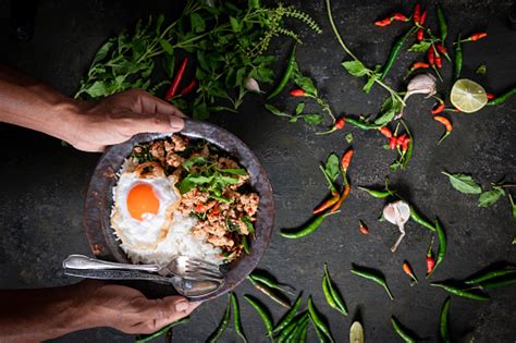 볶은 돼지 고기와 바질을 얹은 밥과 계란 후라이 바질 유명한 전통 태국 음식에 재스민 쌀과 계란 프라이가 제공됩니다 태국 전통 음식 스타일 상위 뷰 거리에 대한 스톡 사진