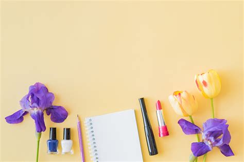 노트북 노란색 튤립과 노란색 배경에 파란색 꽃 창포와 플랫 레이 블로거 또는 프리랜서 작업 공간 꼭대기에 대한 스톡 사진 및