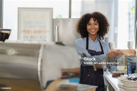 커피숍 카운터 뒤에 서서 고객 음식 및 음료 개념을 받아들이는 웃는 아프리카계 미국인 바리스타 Friendly Match에 대한