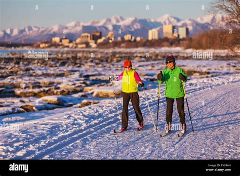 Two People Cross Country Skiing On The Tony Knowles Coastal Trail With