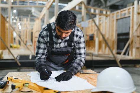 Construction Of Modular Houses Indian Architect On A Construction Site Looks At A Blueprint Construction Of Modular Houses Indian Architect On A Construction Site Looks At A Blueprint