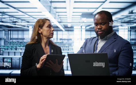 teamworking technicians managing data center with advanced technology using devices coworkers