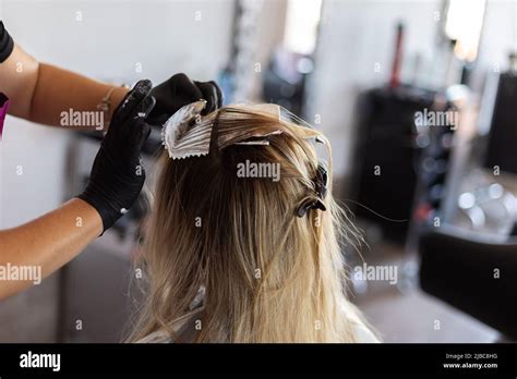 Putting Strand Of Hair With Hair Dye In The Piece Of Foil Colouring Hair At Beauty Salon Stock