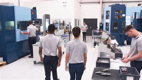 Busy Engineering Workshop With Workers Using Cnc Machinery Stock Image