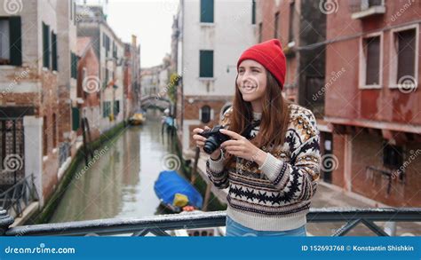 Young Woman Standing On The Bridge And Taking Pictures Of The