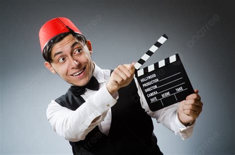 Man With Movie Board Wearing Fez Hat Background And Picture For Free