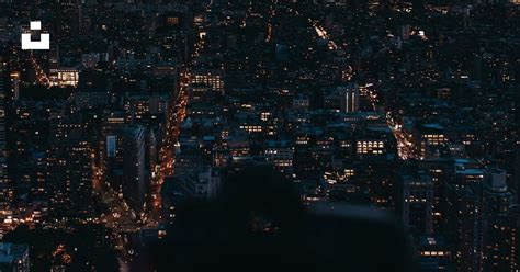 밤 시간 동안 도시의 불빛을 바라보며 건물 가장자리에 앉아 있는 남자 사진 Unsplash의 무료 뉴욕 이미지