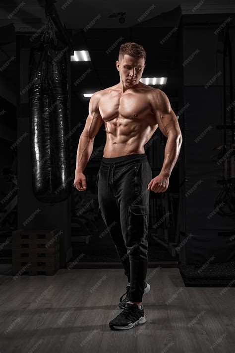 Handsome Man Standing Strong In The Gym And Flexing Muscles Muscular Athletic Bodybuilder