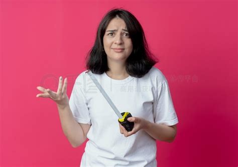 深红色高清图片困惑的年轻漂亮白人女孩拿着卷尺，在深红色背景中展示空空的手，并有复制空间产品实拍免费下载格式编号52267528 千图网