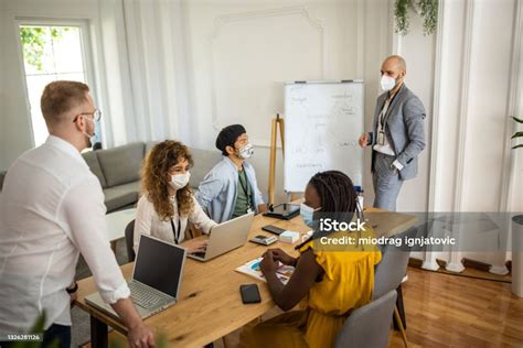 화이트보드 앞에 서서 현대 사무실에서 동료들과 비즈니스에 대해 이야기하는 매니저 20 24세에 대한 스톡 사진 및 기타 이미지 20 24세 25 29세 30 34세