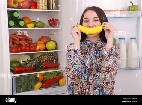 A Young Girl Holds Up A Banana To Her Mouth Imitating A Smile