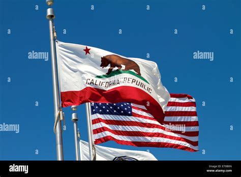 The Flags Of The United States Of America And California Fly Next To