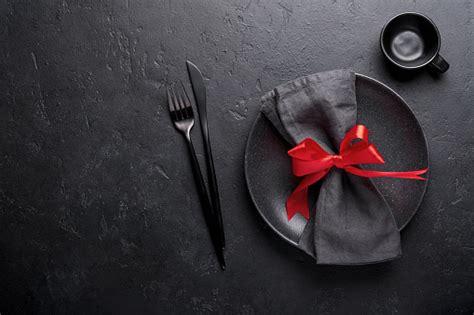 검은 숟가락 포크 칼 깨끗한 빈 검은 색 접시와 빨간 리본냅킨 블랙 백에 세련된 블랙과 골드 칼의 세트 유행과 고급 식사 맨 위 보기입니다 텍스트공간을 복사합니다 0명에