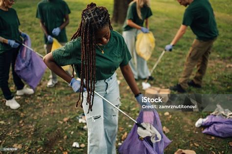 자원봉사자들이 쓰레기 수거기와 봉투를 이용해 공원에서 쓰레기를 줍고 있습니다 20 24세에 대한 스톡 사진 및 기타 이미지 20 24세 20 29세 60 64세