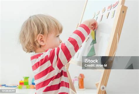 귀여운 어린 아이가 자기 판에서 놀고 집에서 편지 숫자 및 기하학적 모양을 학습합니다 초기 개발을위한 교육적이고 재미있는 실내 활동 2 3 살에 대한 스톡 사진 및 기타