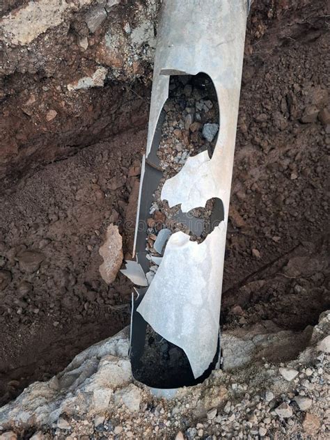 Old Broken Sewer Pipe Lies Exposed In A Trench Revealing Structural