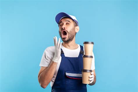 배달 서비스 피곤한 졸린 택배 남자 에 블루 바지 들고 세 커피와 하품 에 지친 지루한 표정 수리공에 대한 스톡 사진 및 기타 이미지 Istock
