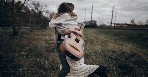 소박한 결혼식 개념 바람이 부는 들판에서 그의 보헤미안 집시 여자와 함께 기타 춤을 추는 남자 세련된 힙스터 커플 포옹 분위기 있는 관능적인 순간 세련된 모습 사진