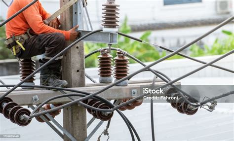 고전압 전력선 유지 보수 직장에서 전기 기사 전신주에서 일하는 전기 기술자 고전압 전력선 건설 배선 및 전선의 위험이 있습니다 안전하게 작업하십시오 정전에 대한 스톡 사진
