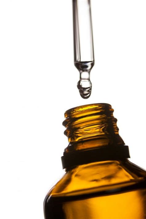 Download Drop Of Oil Dripping From Pipette Into Bottle Of Essential Oil ...