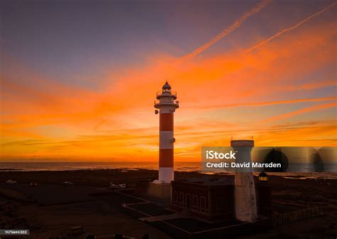 스페인 푸에르테벤투라 카나리아 제도의 엘 코틸로와 코랄레호 근처의 역사적인 파로 델 토스톤 전통 등대 뒤의 놀랍도록 아름다운 일몰 0명에 대한 스톡 사진 및 기타 이미지