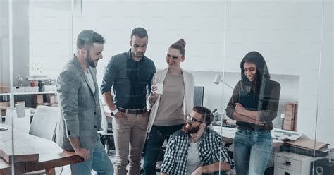 캐주얼웨어를 입은 젊은 현대인들이 창의적인 사무실의 유리 벽 뒤에 서서 바닥에 놓인 큰 청사진을 바라보며 사업 전략을 계획하고 있다 사진 Unsplash의 마루 이미지