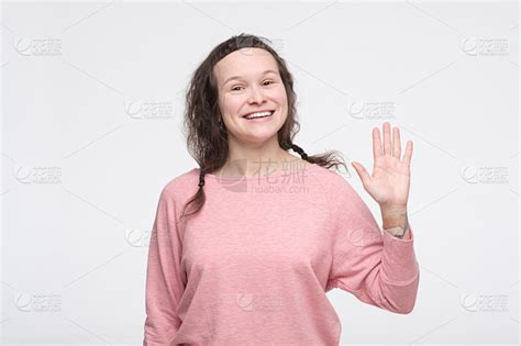 穿着粉红色衣服的女人挥手向她的朋友问好。