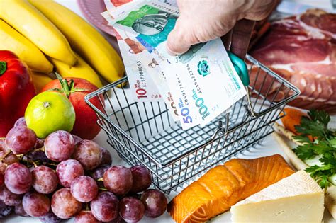 콜롬비아의 식품 가격 상승 인플레이션 상승의 개념 과일 야채 고기 치즈 내부에 쇼핑 바구니와 콜롬비아 페소의 다량을 들고있는 손 콜롬비아에 대한 스톡 사진 및 기타 이미지