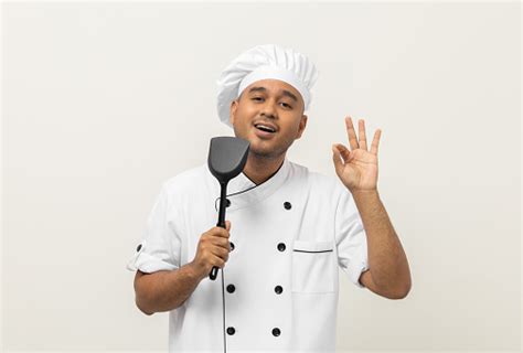 슈퍼 스타 노래 마스터 셰프 유니폼을 입은 젊은 행복한 아시아 요리사는 고립 된 흰색 배경의 부엌에서 노래하는 목소리와 춤을 즐깁니다 인도 남자 직업 레스토랑과 호텔 가수에