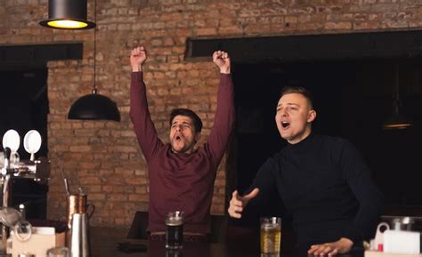 펍에서 Tv로 스포츠를 시청하는 행복한 친구들 좋아하는 팀의 승리를 응원하고 맥주를 마시고 함께 목표를 축하하고 공간을 복사합니다 프리미엄 사진