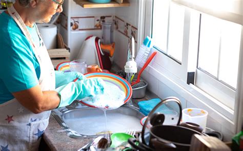 앞치마와 장갑을 착용한 노인 여성의 회색 머리가 설거지 부엌의 코너입니다 직장에서 할머니 창에서 밝은 빛 가사 집안일에 대한 스톡 사진 및 기타 이미지 Istock