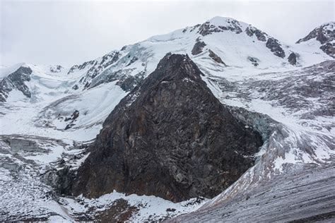 회색 흐린 하늘 아래 큰 눈 산에 두 개의 빙하 빙하가있는 극적인 풍경 높은 고도의 빙하가있는 산 꼭대기 흐린 산의 우울한 풍경