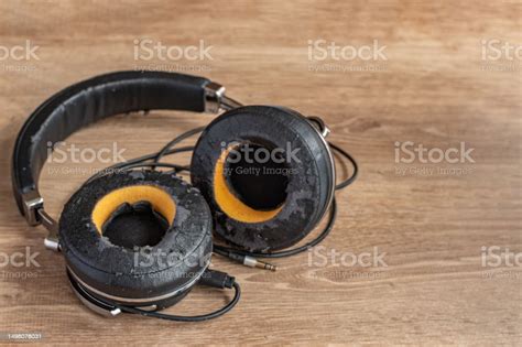 낡은 깨진 헤드폰이 가벼운 나무 탁자에 클로즈업되어 있다 전기 장비 및 전기 장치의 수리 개념 고품질 음악 감상을 위한 헤드폰 0명에 대한 스톡 사진 및 기타 이미지