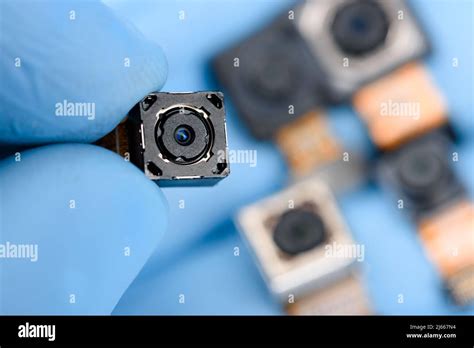 Smartphone Camera Module In Researcher Hand With Other Cell Phone Camera Sensors On Background