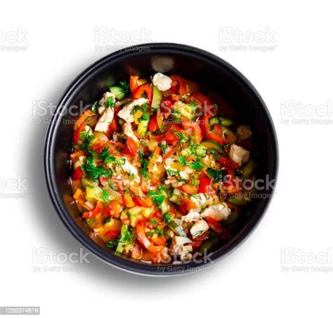 군침이 도는 맛있는 야채 붉은 피망 당근 오이 딜 그린스 토마토 양파 잘게 썬 프라이드 치킨 고기로 함께 팬에 흰색 배경 상단