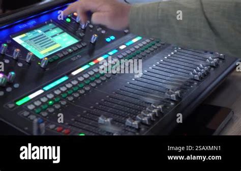 Sound Engineer Working At The Mixing Console Adjusting Faders Sound