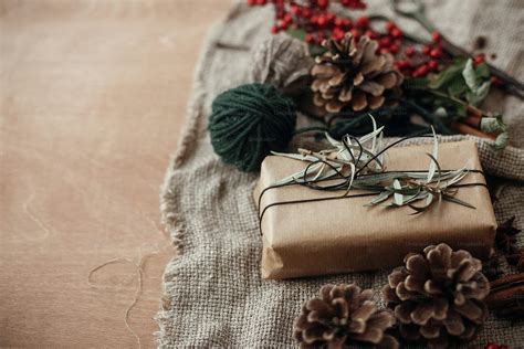 녹색 가지와 전나무 가지 딸기 아니스 솔방울 소박한 나무 배경에 계피가 있는 세련된 소박한 크리스마스 선물 상자 간단한 에코 선물 분위기 있는 분위기 텍스트를