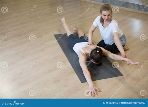 Καυκάσια λεπτή κοπέλα που κάνει μαξιλάρια γυμνάζεται στο χαλάκι στο πάτωμα στο γυμναστήριο