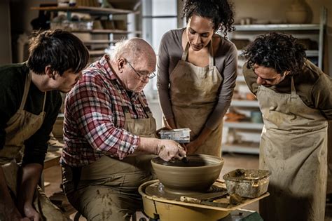 회전하는 도자기 바퀴에 그릇을 조각하는 방법을 학생들에게 가르치는 마스터 도공 35 39세에 대한 스톡 사진 및 기타 이미지 35 39세 40 44세 70 79세