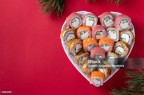 연어 참치 장어로 구성된 초밥 세트와 함께 필라델피아 치즈를 접시에 담은 아시아 음식이 빨간색 배경에 하트 모양으로 담겨 있다 평면도 복사 공간 초밥에 대한 스톡 사진 및