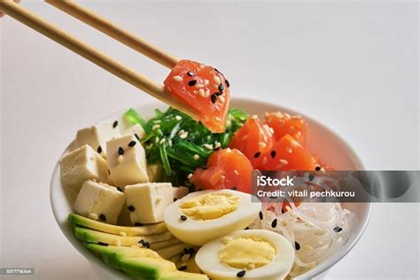 華 샐러드 달콤한 양파 메 추 라 기 계란 흰색 배경 평면도에 고립 된 흰색과 검은 참 깨 간장 소스 뿌려 젓가락 연어 아보카도 밥 그릇을 찌를 들고 0명에 대한 스톡 사진