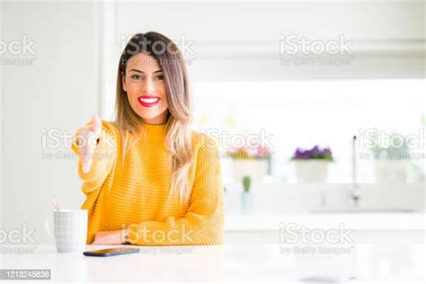 젊은 아름다운 여자는 인사와 환영으로 악수를 제공 친절 미소 집에서 커피 한 잔을 마시는 성공적인 비즈니스 갈색 머리에 대한 스톡 사진 및 기타 이미지 Istock