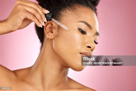 흑인 여성 얼굴에 오일과 세럼 스킨케어 광택 또는 스튜디오의 분홍색 배경에 미적 피부과 여성 모델 얼굴 화장품 및 히알루 론산