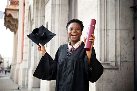졸업 가운을 입은 아프리카 계 미국인 여학생이 졸업장을 들고 있습니다 25 29세에 대한 스톡 사진 및 기타 이미지 25