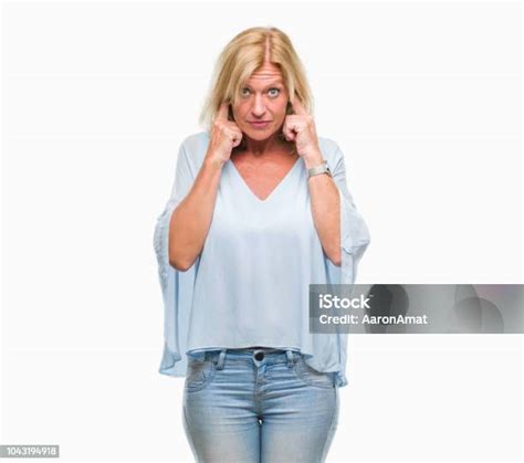 시끄러운 음악의 소음에 대 한 짜증이 식이 손가락으로 귀를 덮고 격리 된 배경 위에 중 년 금발 비즈니스 여자 청각 장애인 개념입니다 귀 부분에 대한 스톡 사진 및 기타