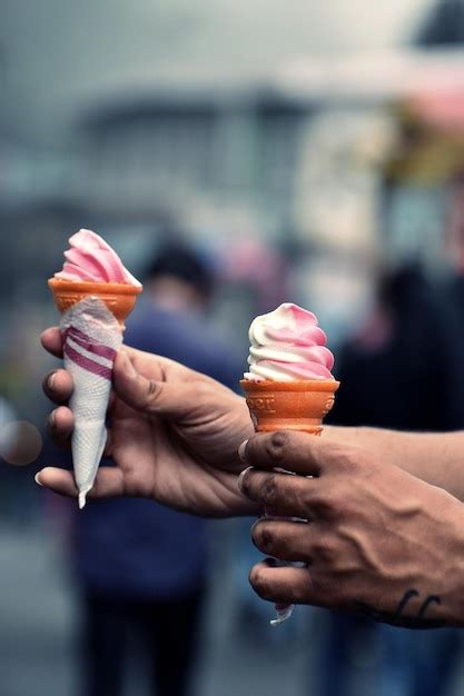 Premium Photo Close Up Of Hands Holding Ice Cream Cones