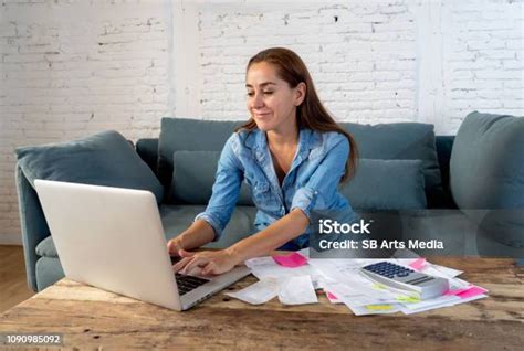 매력적인 주부 기업가 여자 회계 비용 요금 모기지 세금 및 지불 청구서 노트북과 집에서 소파에 앉아 계산기 행복 은행 및 성공에 재정 무료 빚을 젊은 여자에 대한 스톡 사진