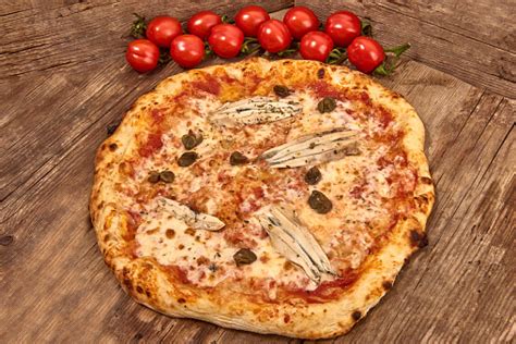 집에서 만든 신선한 맛 있는 음식 피자 로마나 오순절 멸 치 케이 퍼 오 레가 노 나무 테이블에 고립 된 맛 있는 이탈리아