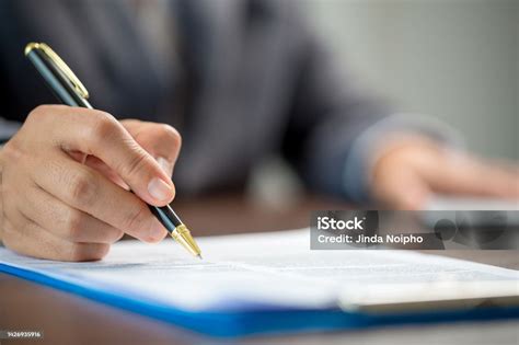 직장 근접 촬영 사람 전문 사업가가 책상에 앉아 펜 서명 또는 서명 계약서를 소지합니다 직장 사무실에서 서류 양식 법인에 계약서를 작성하는 직원 여성 개념에 대한 스톡 사진